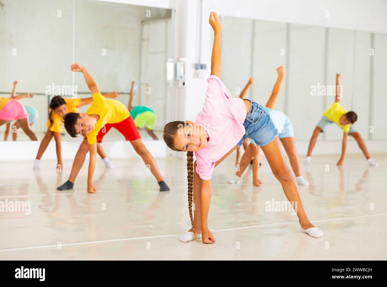 Sporty ten years old girl doing stretching warm-up in dance class Stock ...