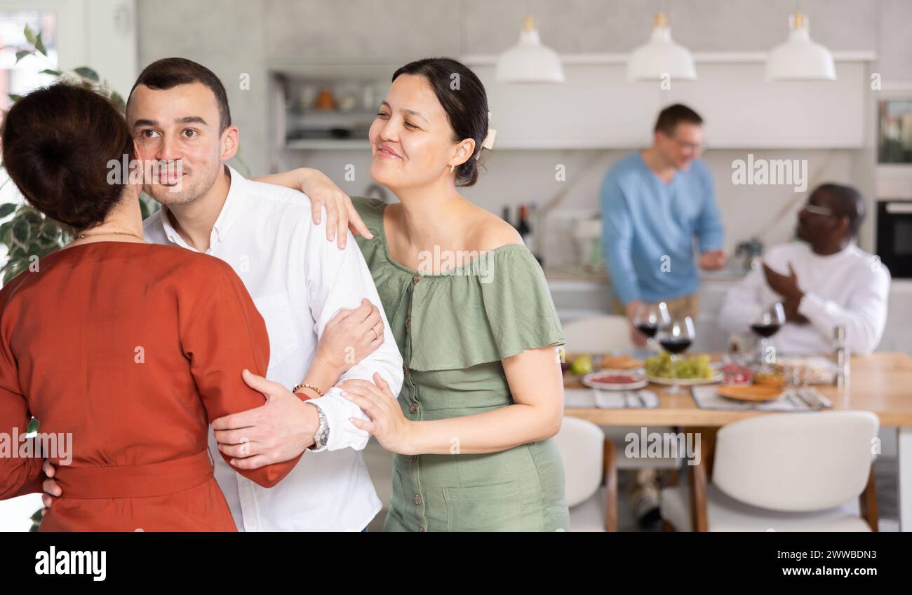 Married couples meet at home for festive dinner. Greet each other Stock ...