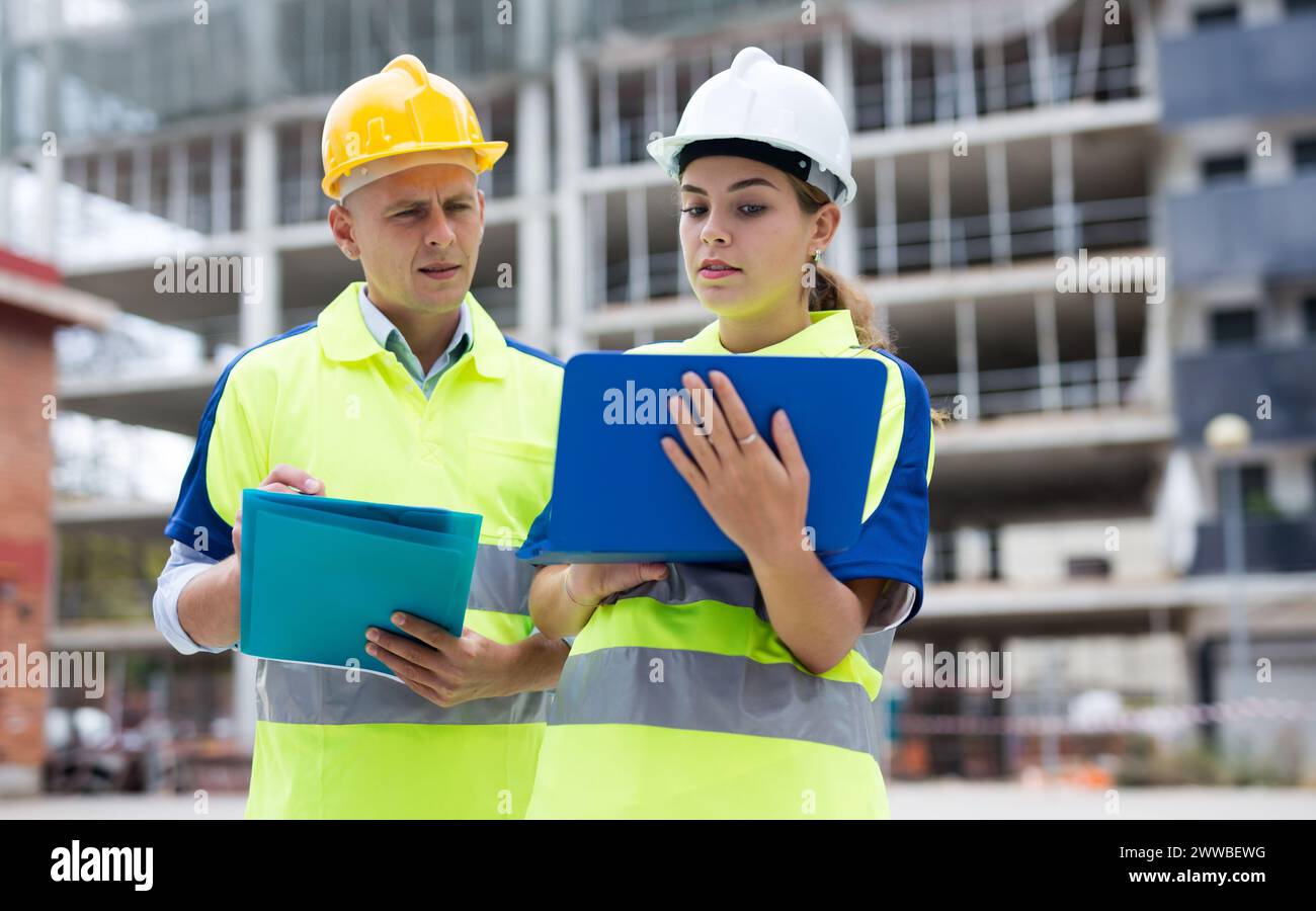 Two architects with laptop discussing construction plan Stock Photo - Alamy