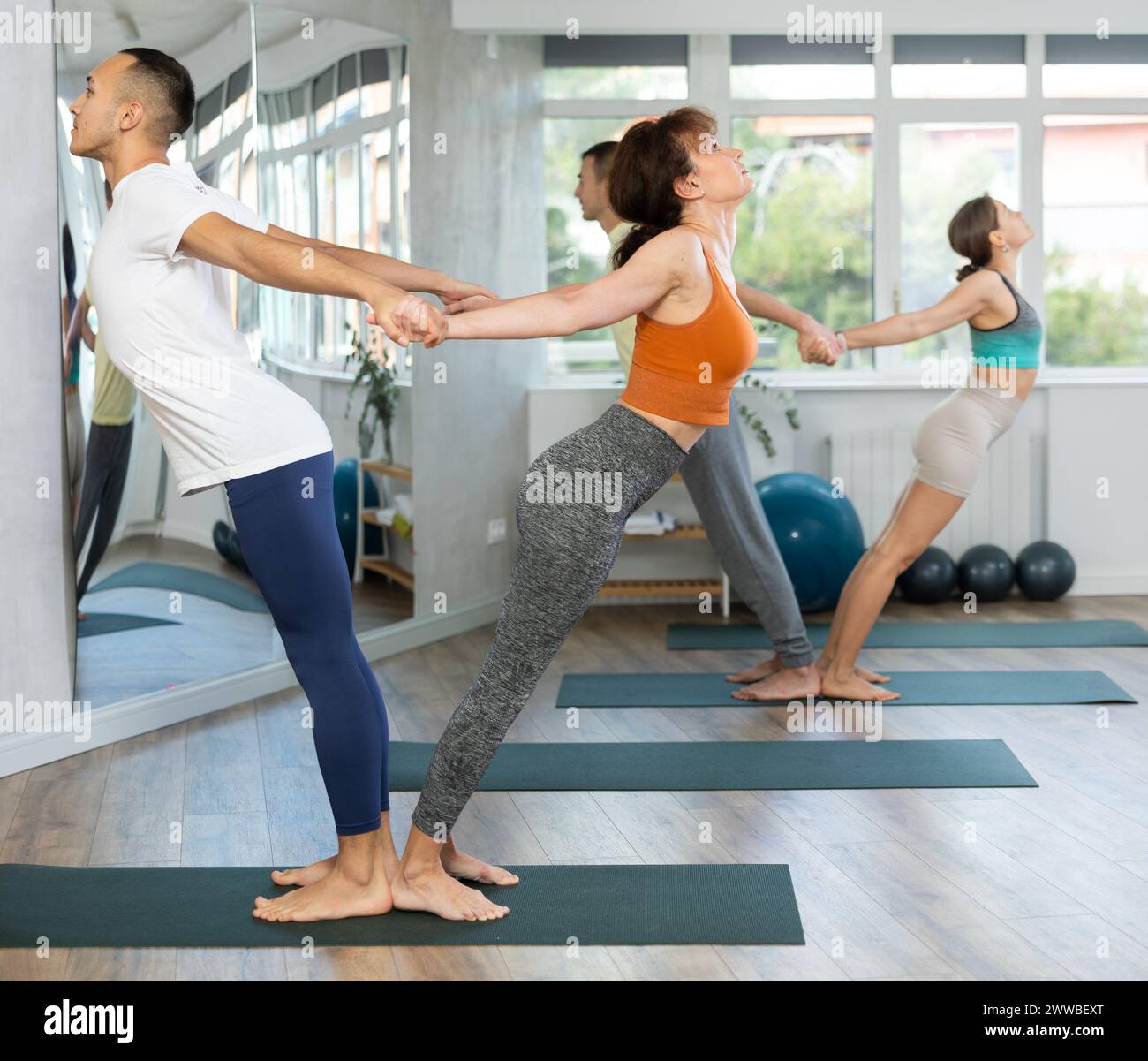 Lovers of active lifestyle perform pair yoga backbend balance pose in gym Stock Photo - Alamy