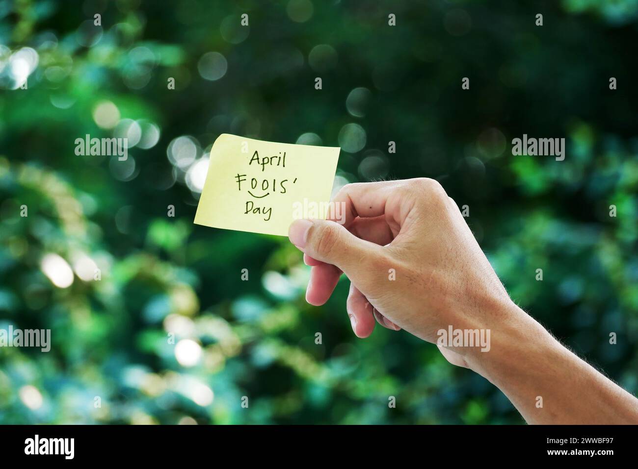 Hand holding a stick note with April Fools Day text Stock Photo - Alamy