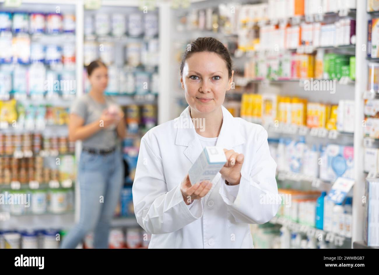 In pharmacy, apothecary holds package with cream for sensitive skin and ...
