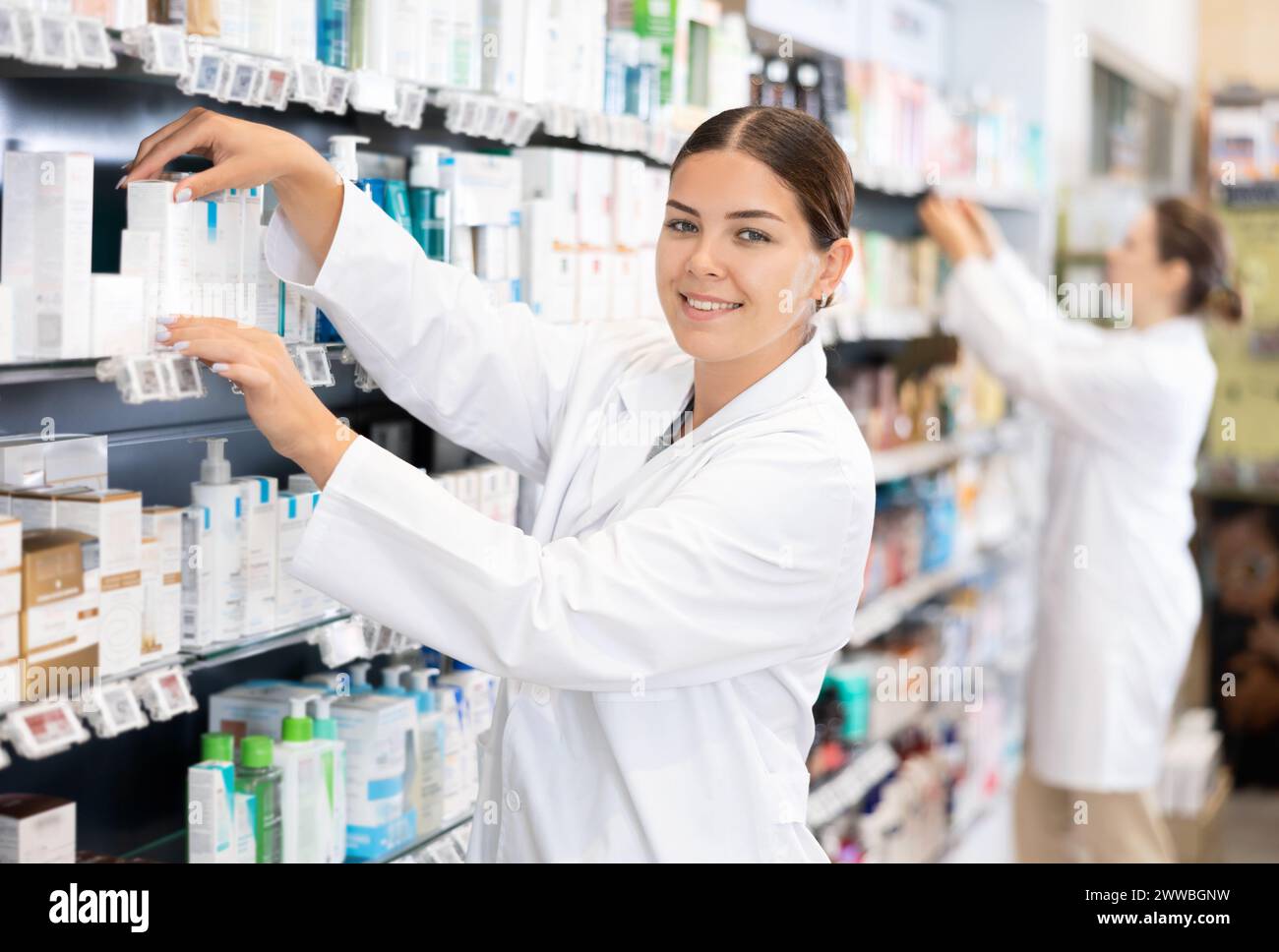 Female pharmacist puts goods on the shelves - healing cosmetics and ...