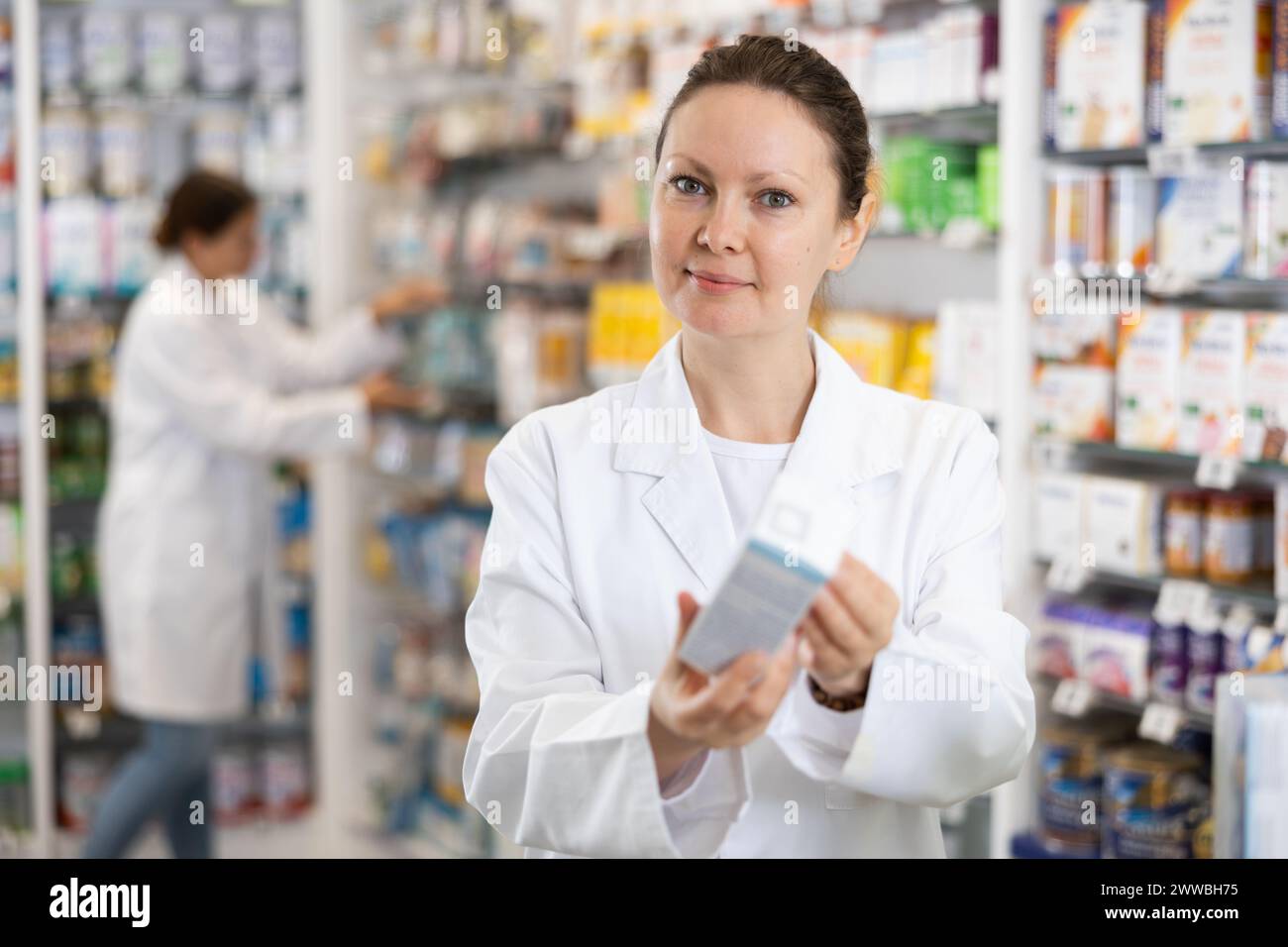 In pharmacy, apothecary holds package with cream for sensitive skin and ...
