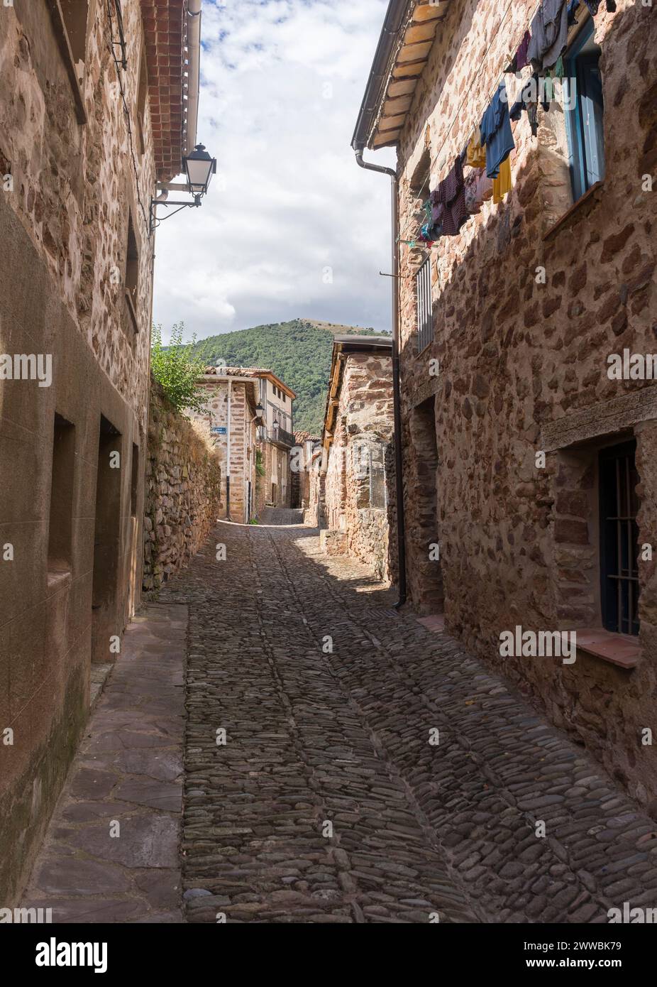 A narrow alley with a stone wall on each side. The alley is lined with ...