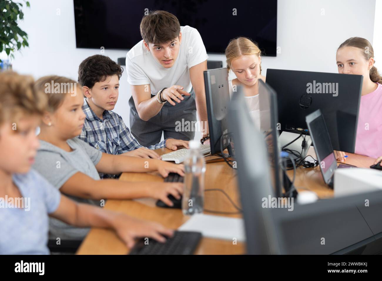 Positive man teacher together with the boy teaches how to work on ...