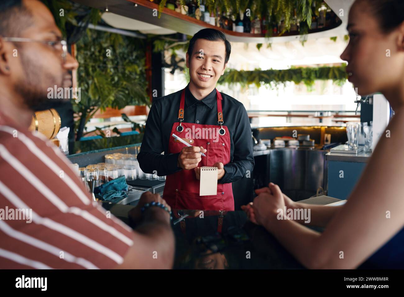 Smiling waiter taking food order in restaurant Stock Photo - Alamy