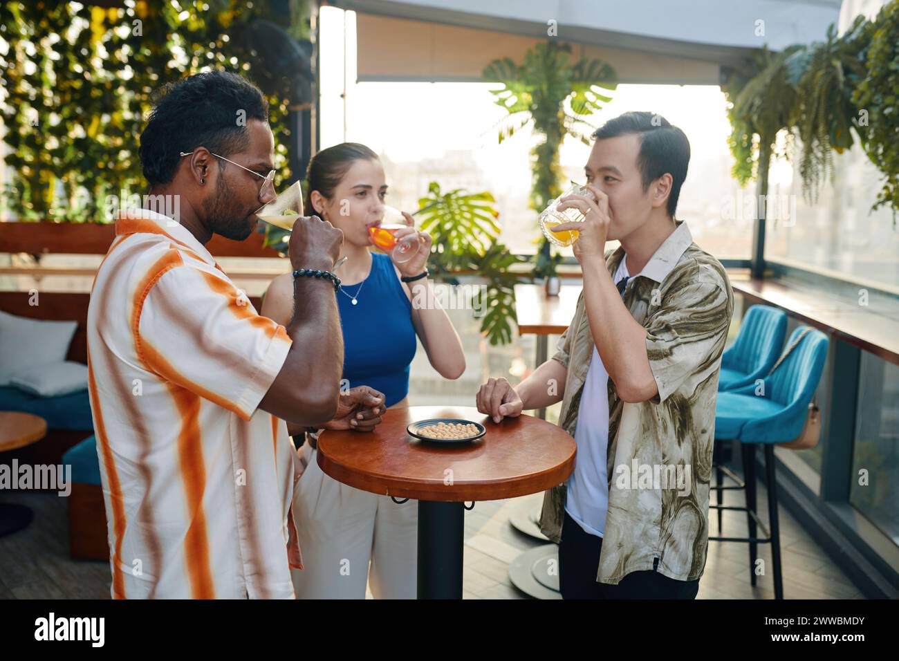 Group of colleagues drinking cocktails in bar after work Stock Photo ...