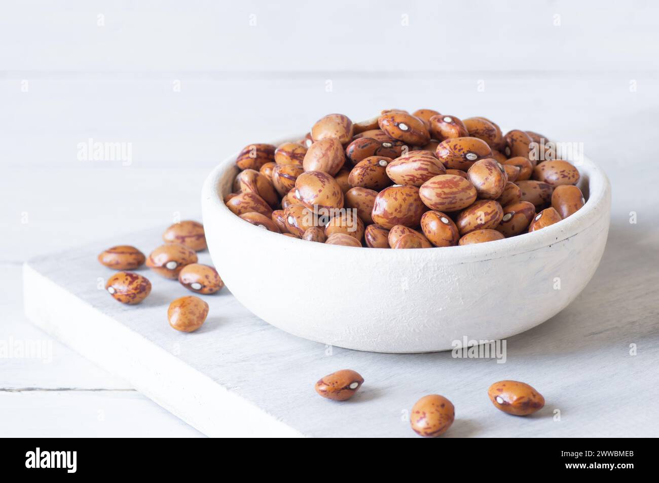 Uncooked dried roman beans in bowl or spoon on table, heap of legume ...