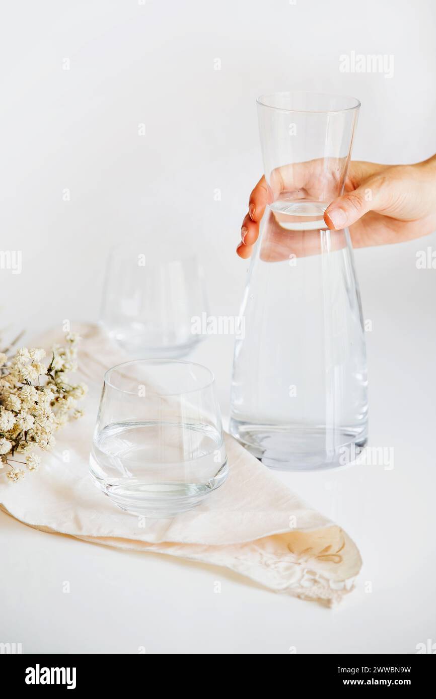 Person pouring mineral water into a glass, process. Glass cup ...