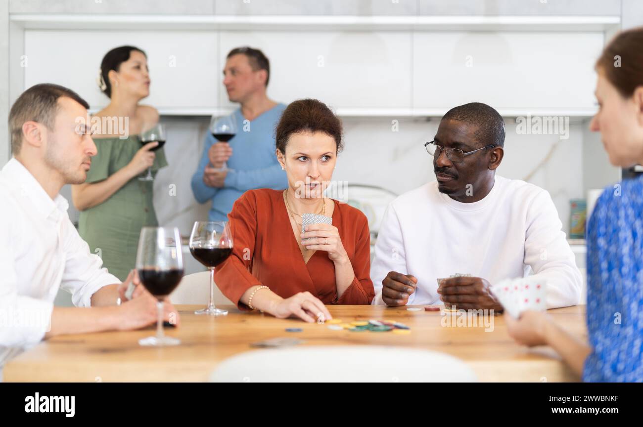 Woman placing bet during friendly poker game at home Stock Photo - Alamy
