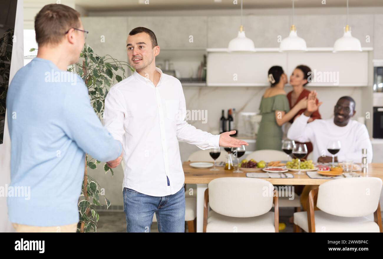Two men smiled and greeted each other with a firm handshake before ...