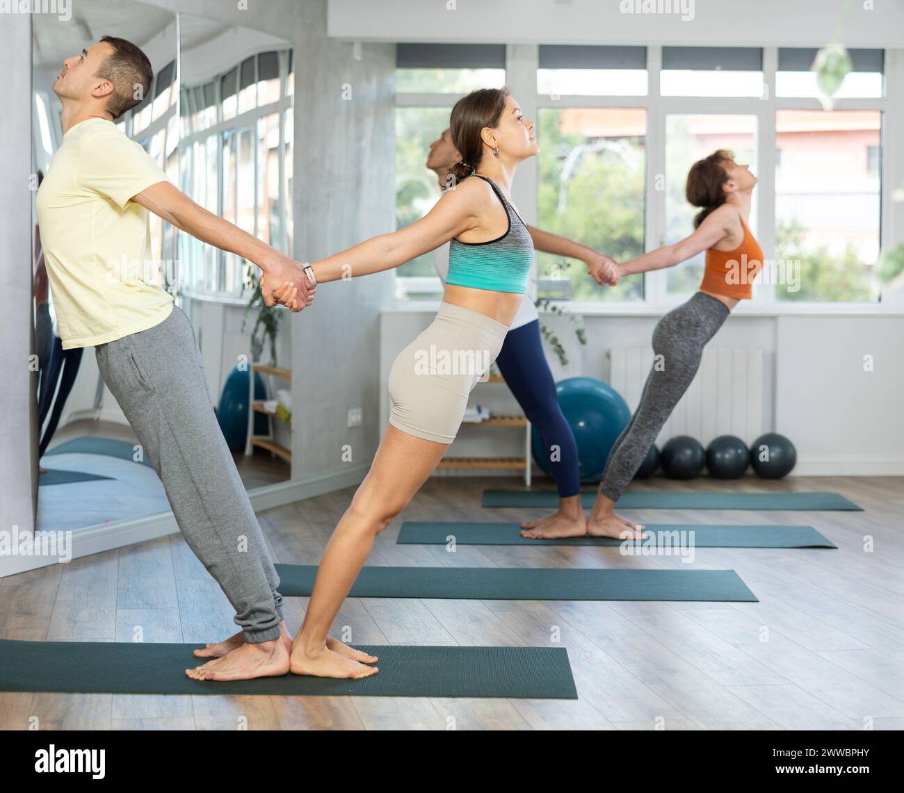 Lovers of active lifestyle perform pair yoga backbend balance pose in ...