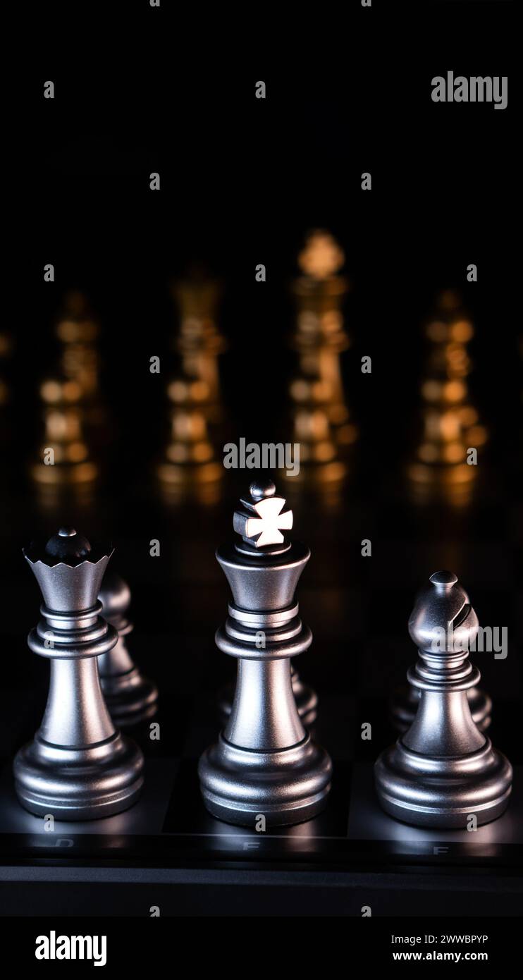 Silver chess pieces in focused light. Chessmen on a black background ...