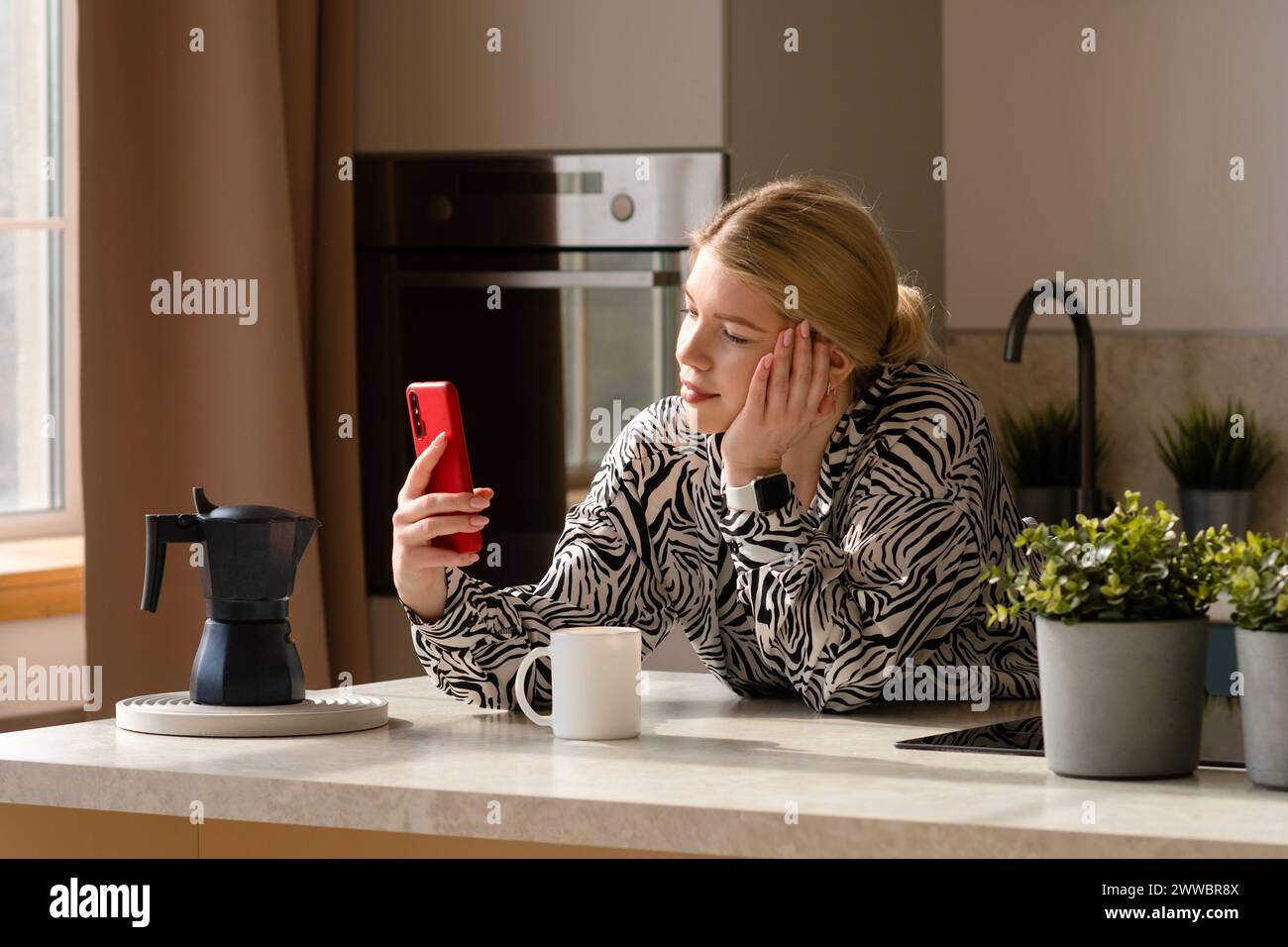 Woman multitasking with phone and coffee. Attractive girl scrolls ...