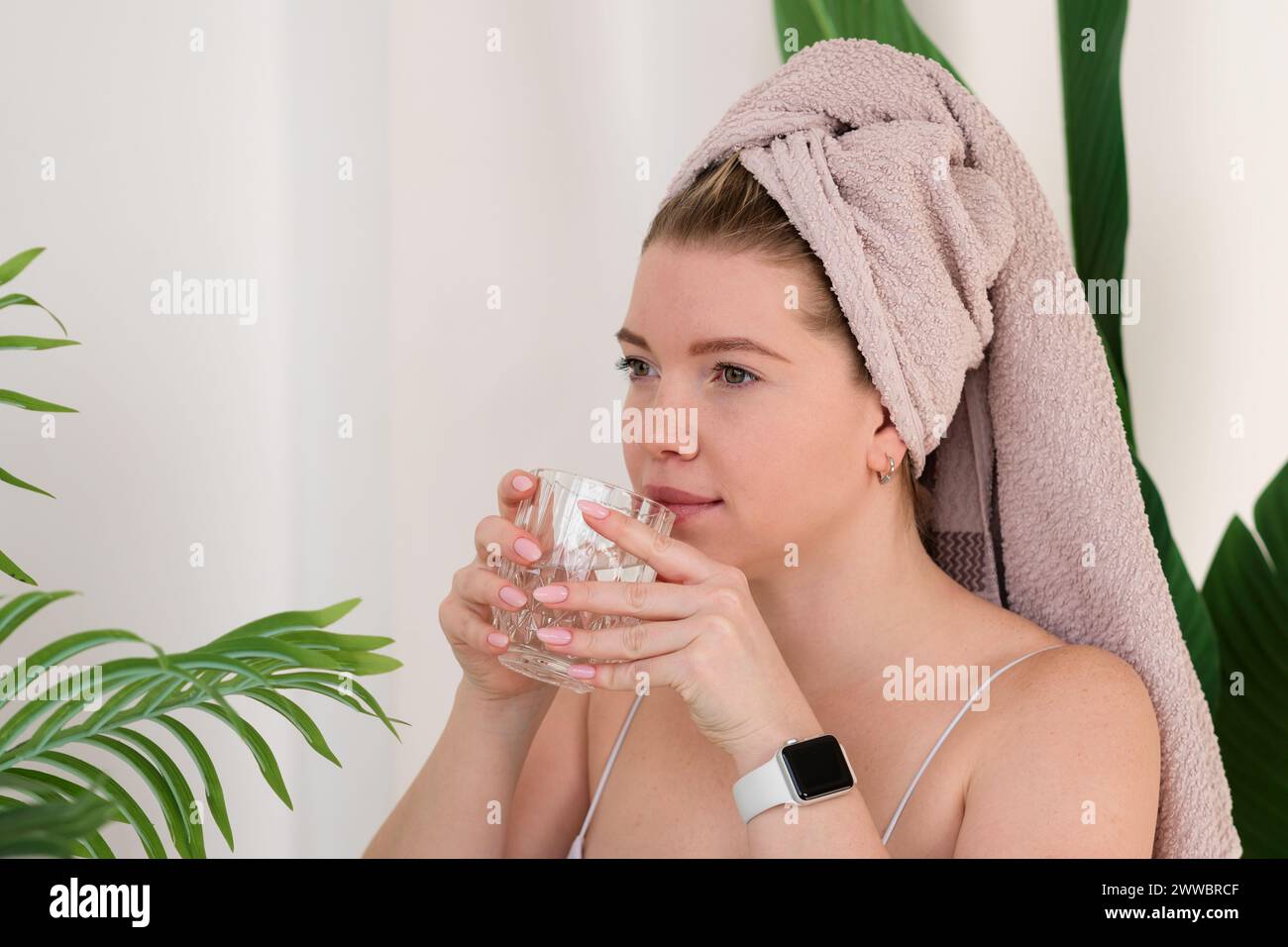 Woman drinking water during skincare routine. Morning self-care routine ...
