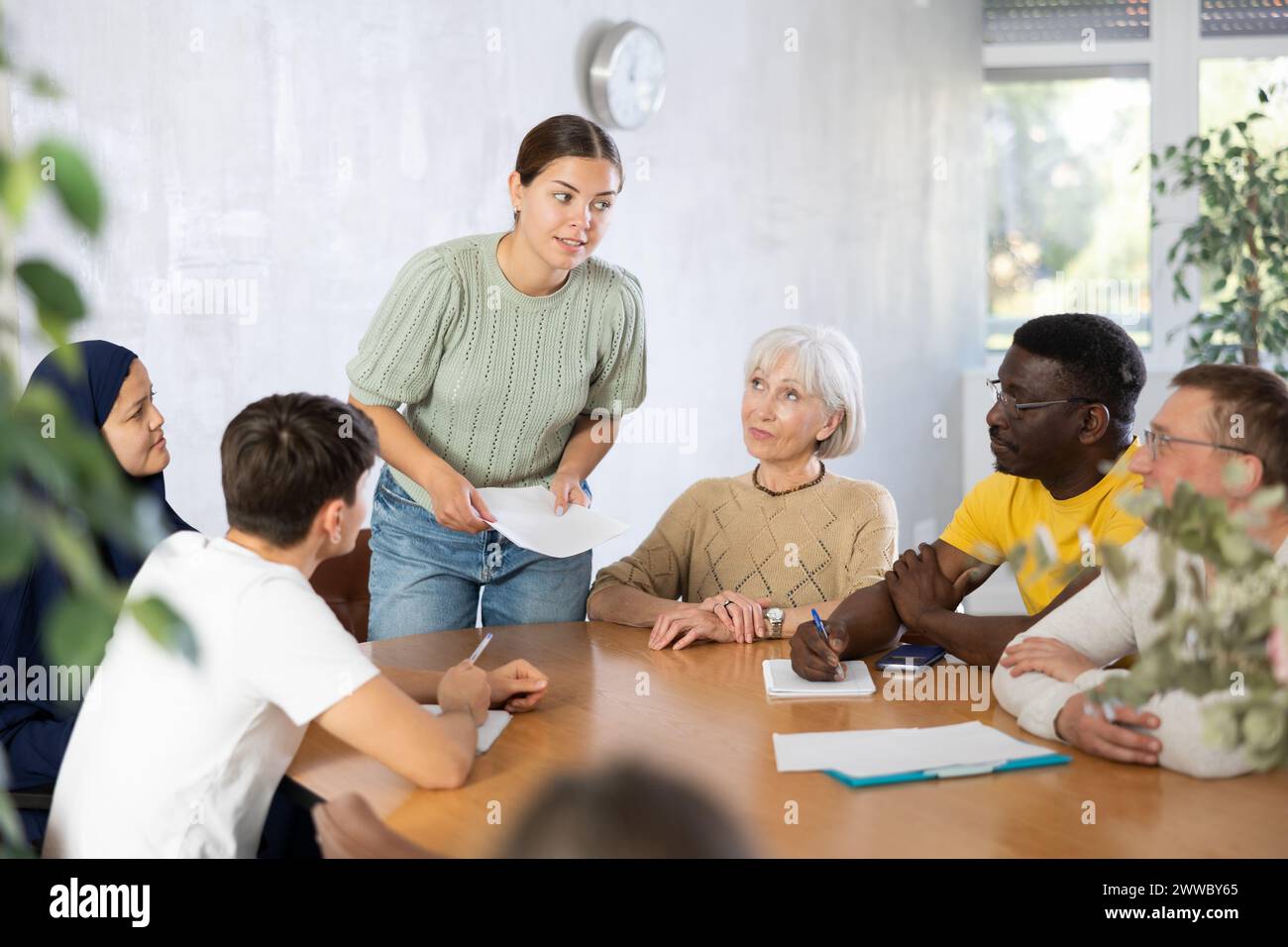 Group of multinational people discussing documents at table Stock Photo ...