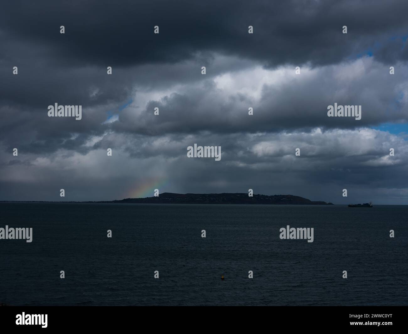 A view of Howth with clouds and a rainbow forming. Dublin city, Ireland ...