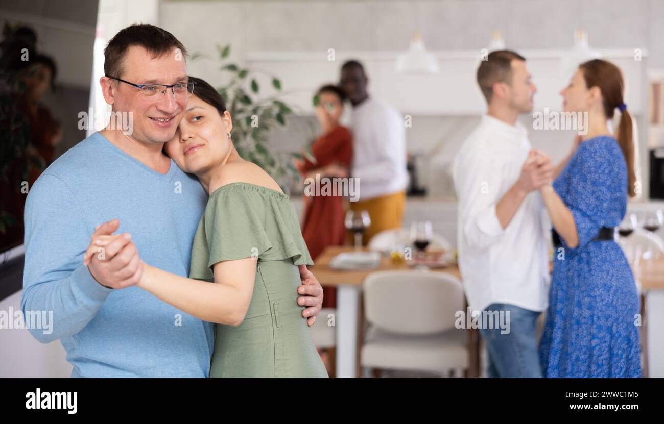 Friends party - men and women of different nationalities dancing slow ...