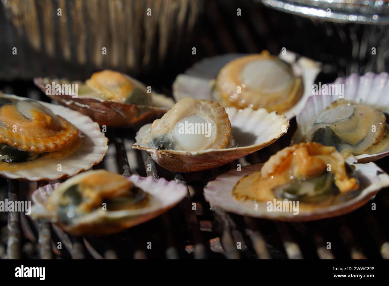various types of clams are grilled on a grill and then dipped in ...