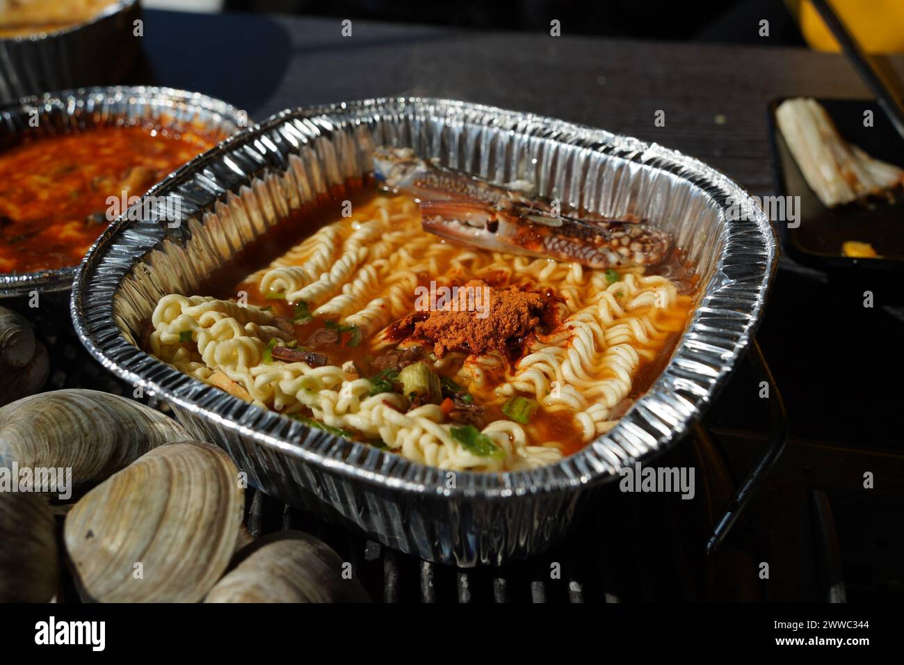 Instant ramen boiled in an aluminum disposable container with seafood ...