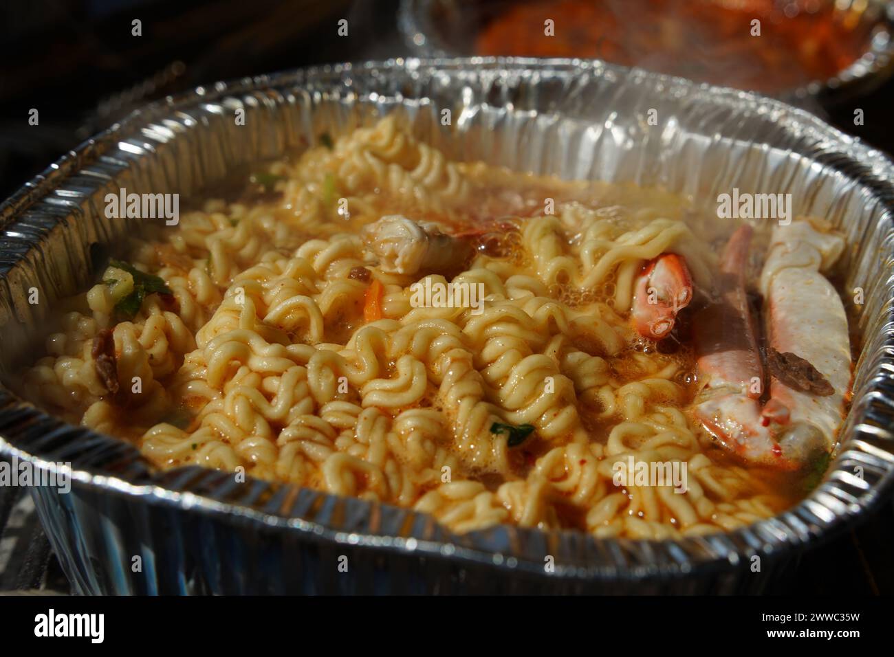 Instant ramen boiled in an aluminum disposable container with seafood ...