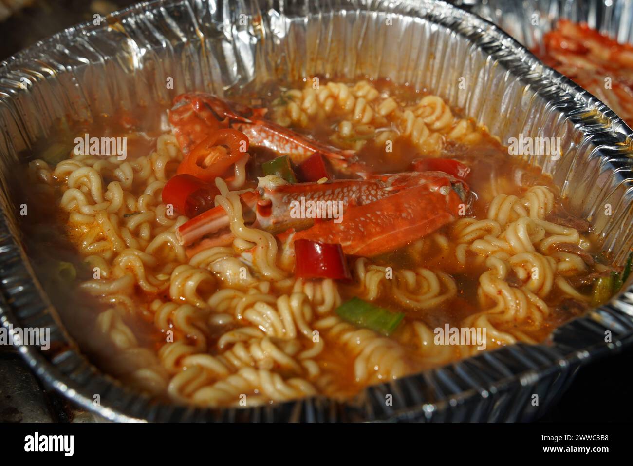 Instant ramen boiled in an aluminum disposable container with seafood ...