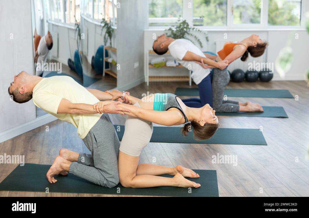 Two young people yogi doing balance back stretch acro yoga pose at ...