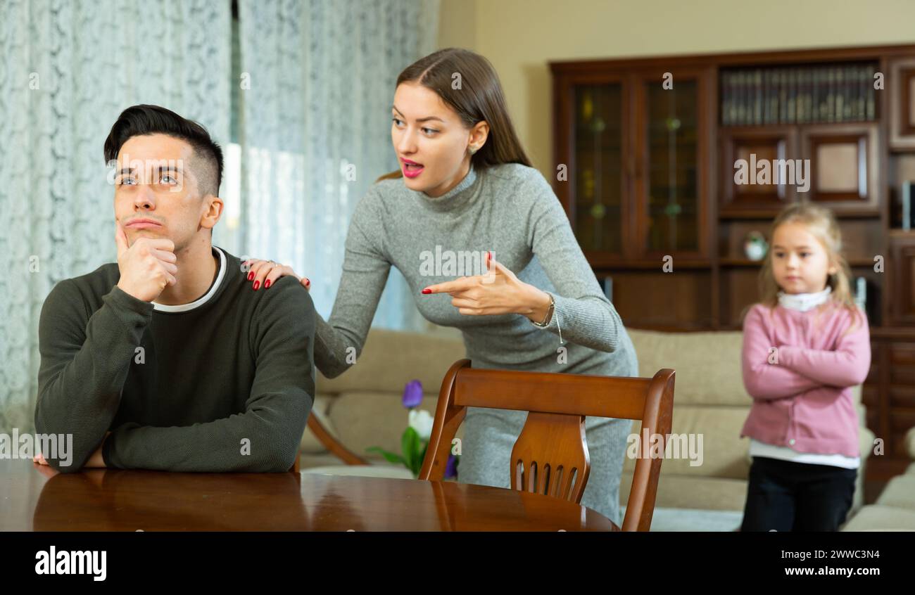 Frustrated man with irritated wife rebuking him Stock Photo - Alamy