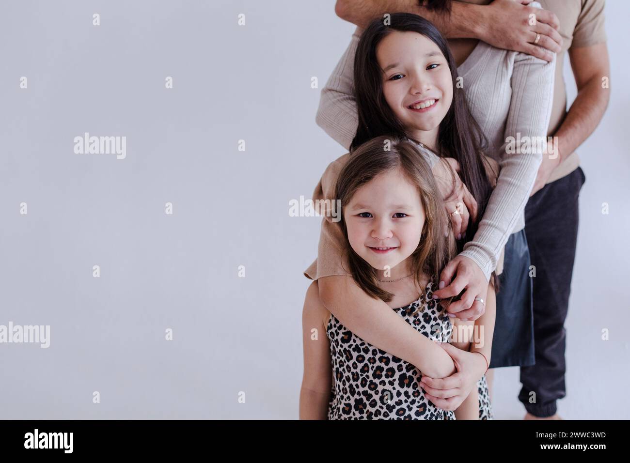 Family embracing each other from behind while standing at studio Stock ...