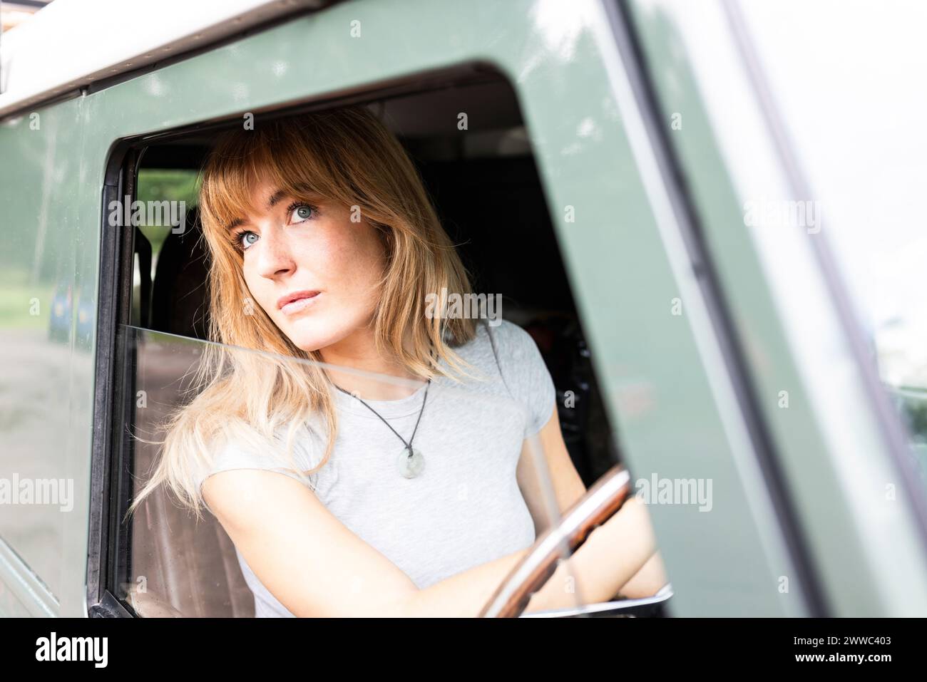 Beautiful woman looking through car window Stock Photo - Alamy
