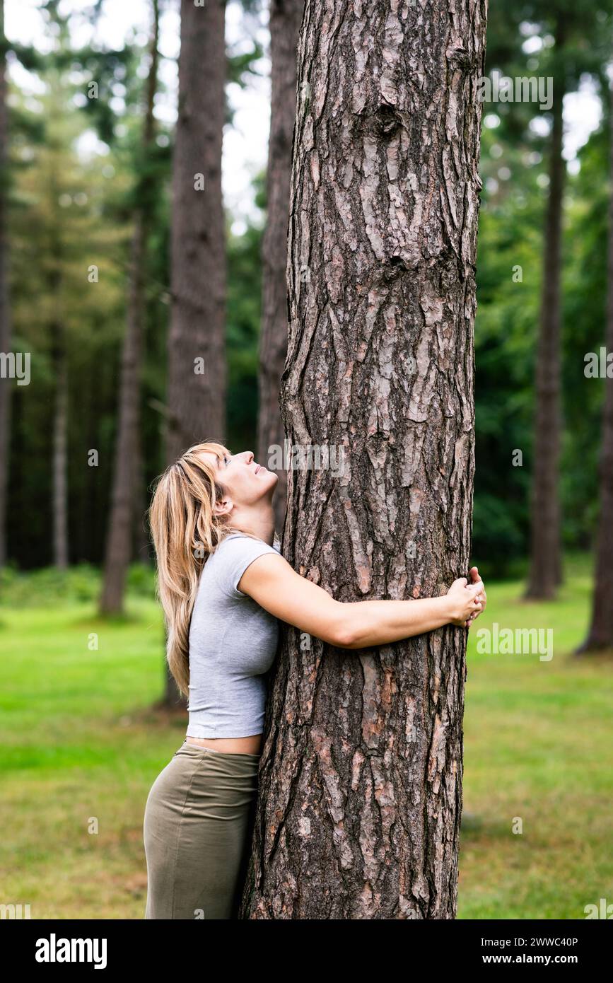Young beautiful woman hugging tree in forest Stock Photo - Alamy