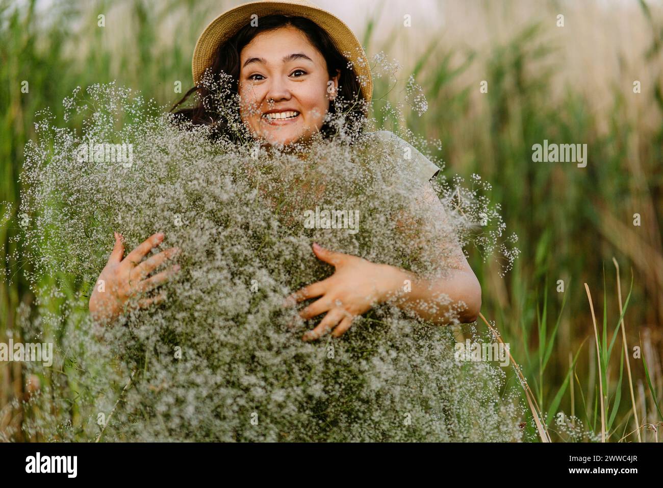 Cheerful mature woman with bunch of gypsophila flowers in field Stock ...