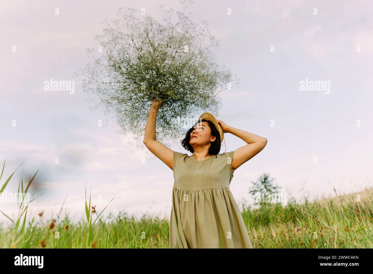 Mature woman with bunch of gypsophila flowers in field Stock Photo - Alamy