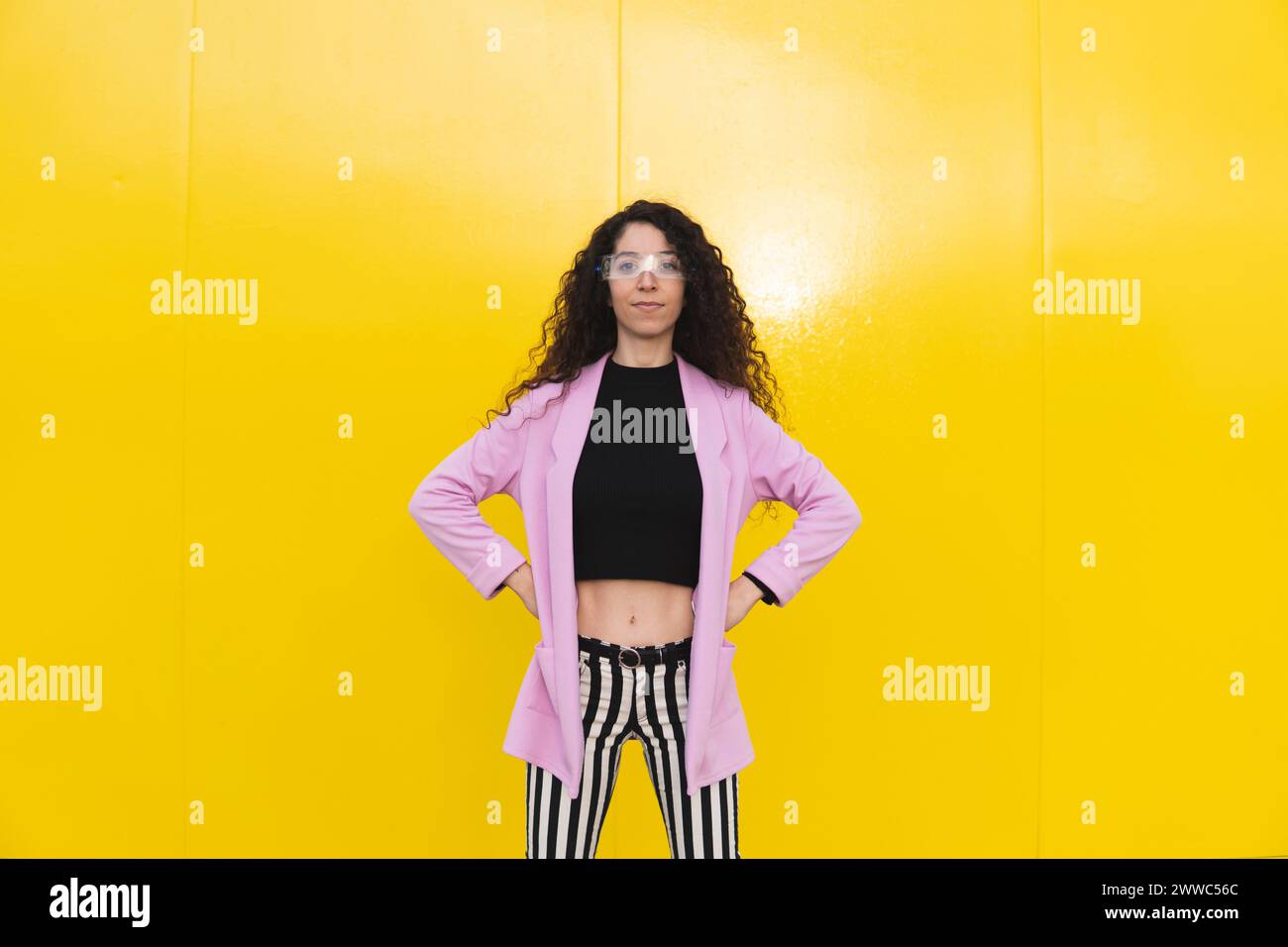 Confident woman standing arms akimbo hi-res stock photography and ...