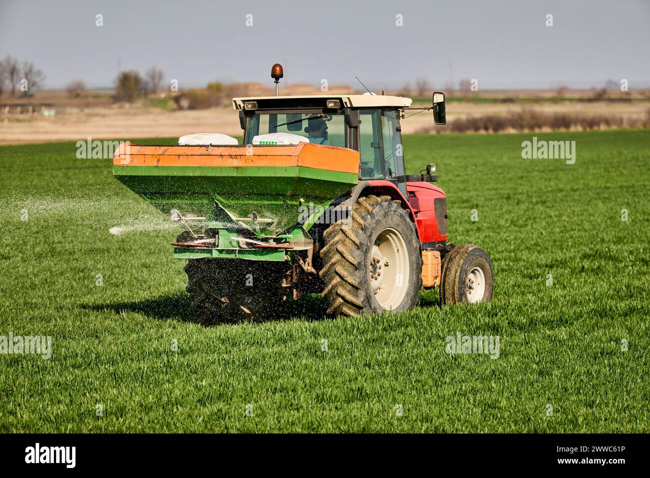 Tractor spreading fertilizer through sprayer on crops in field Stock ...
