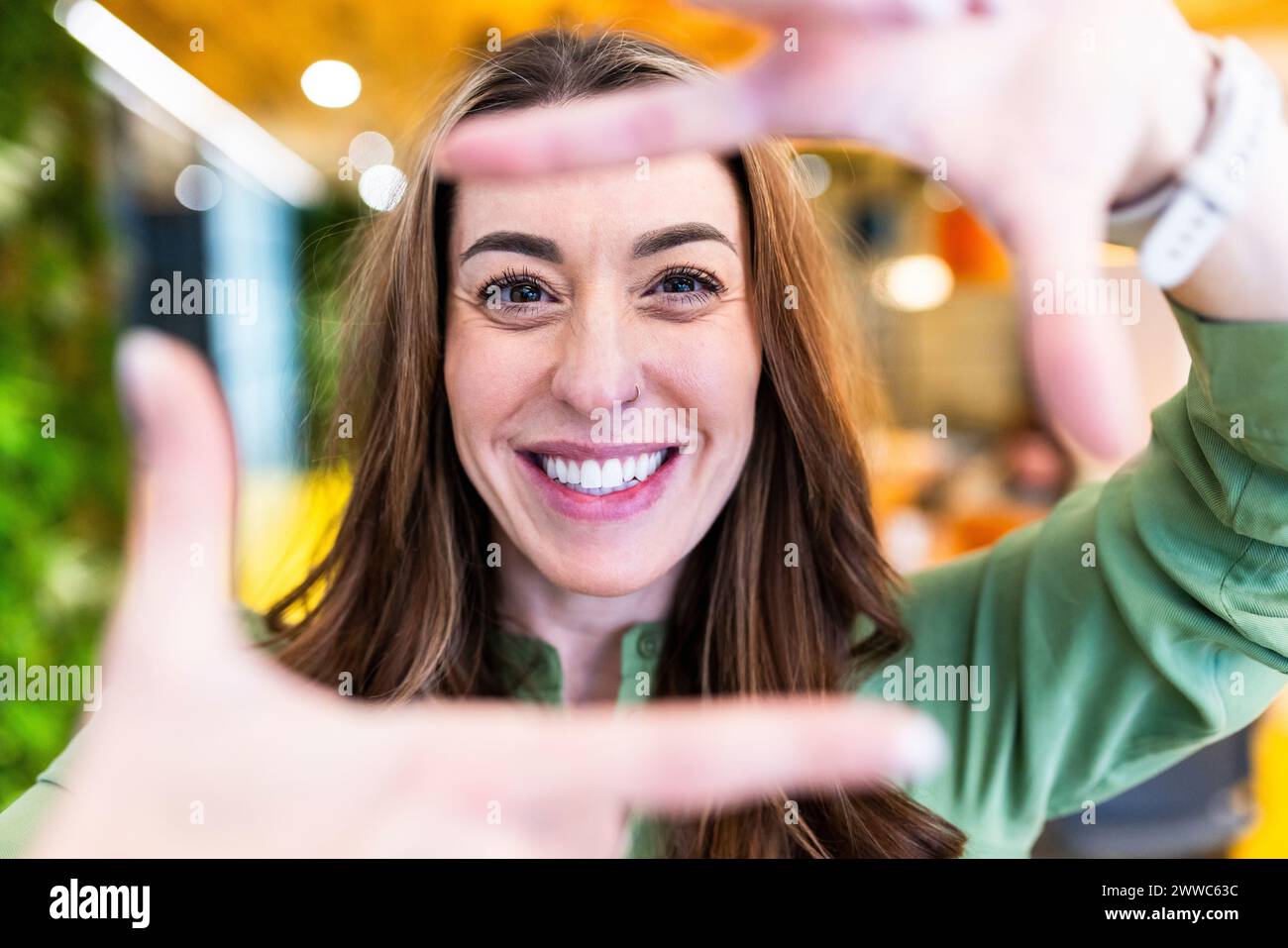 Happy businesswoman making finger frame in office Stock Photo - Alamy