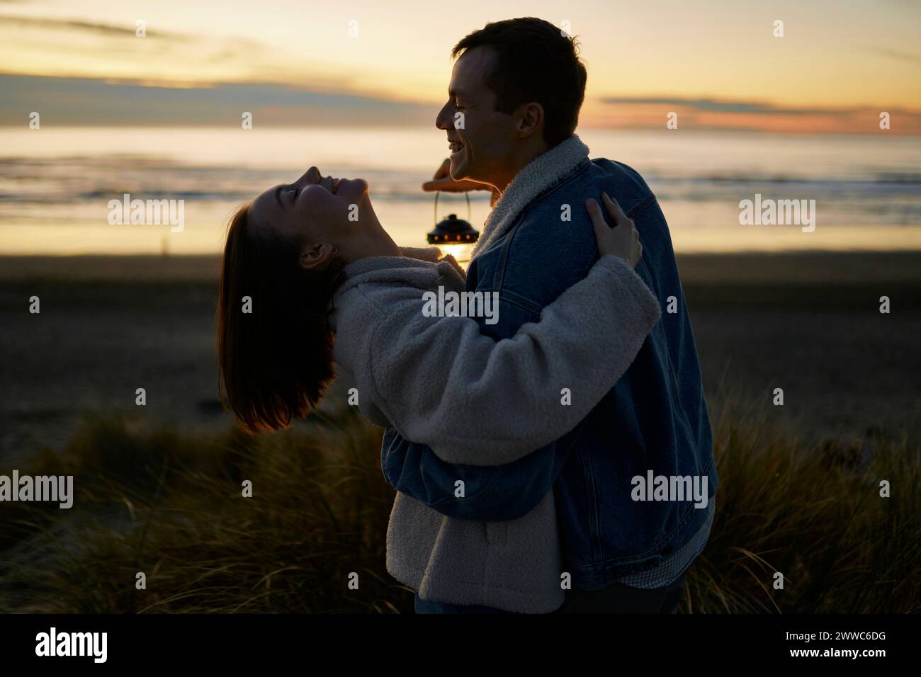 Happy couple hugging and dancing at beach Stock Photo - Alamy