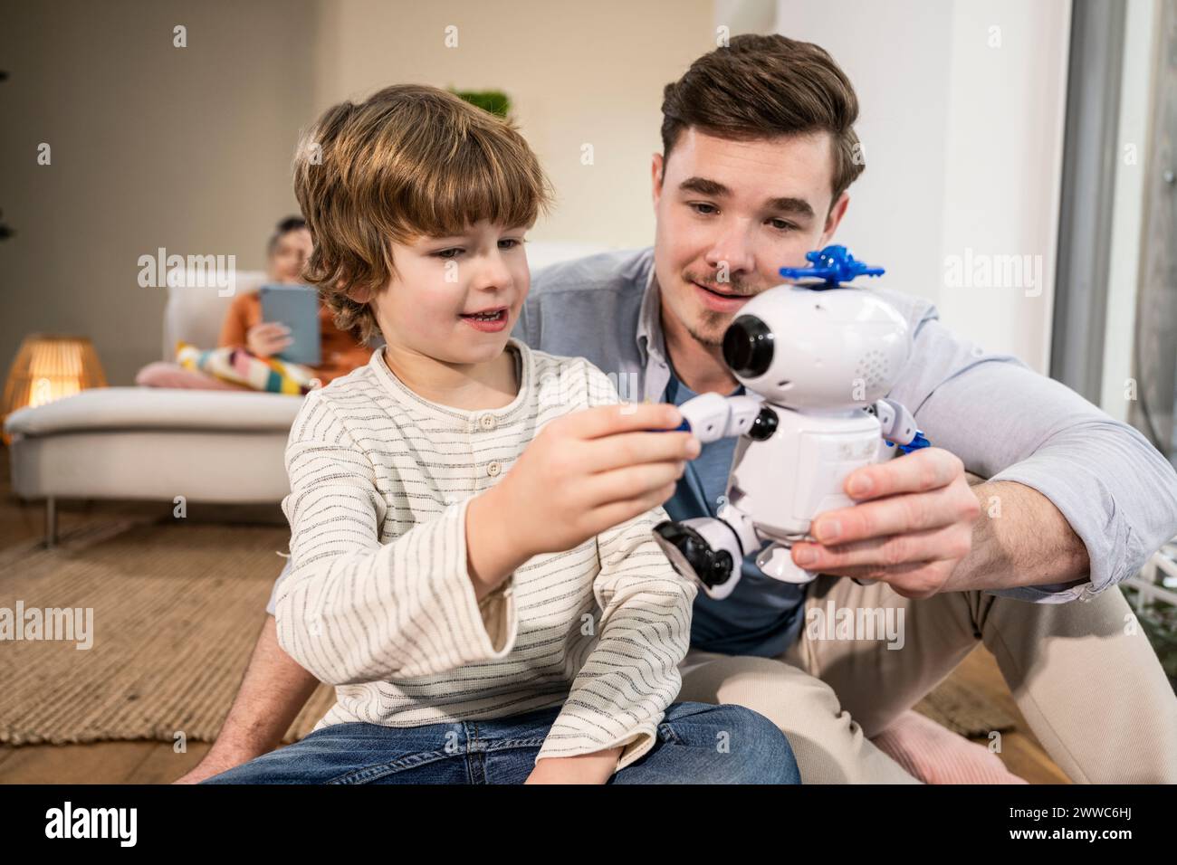 Happy father and son playing with toy robot at home Stock Photo - Alamy
