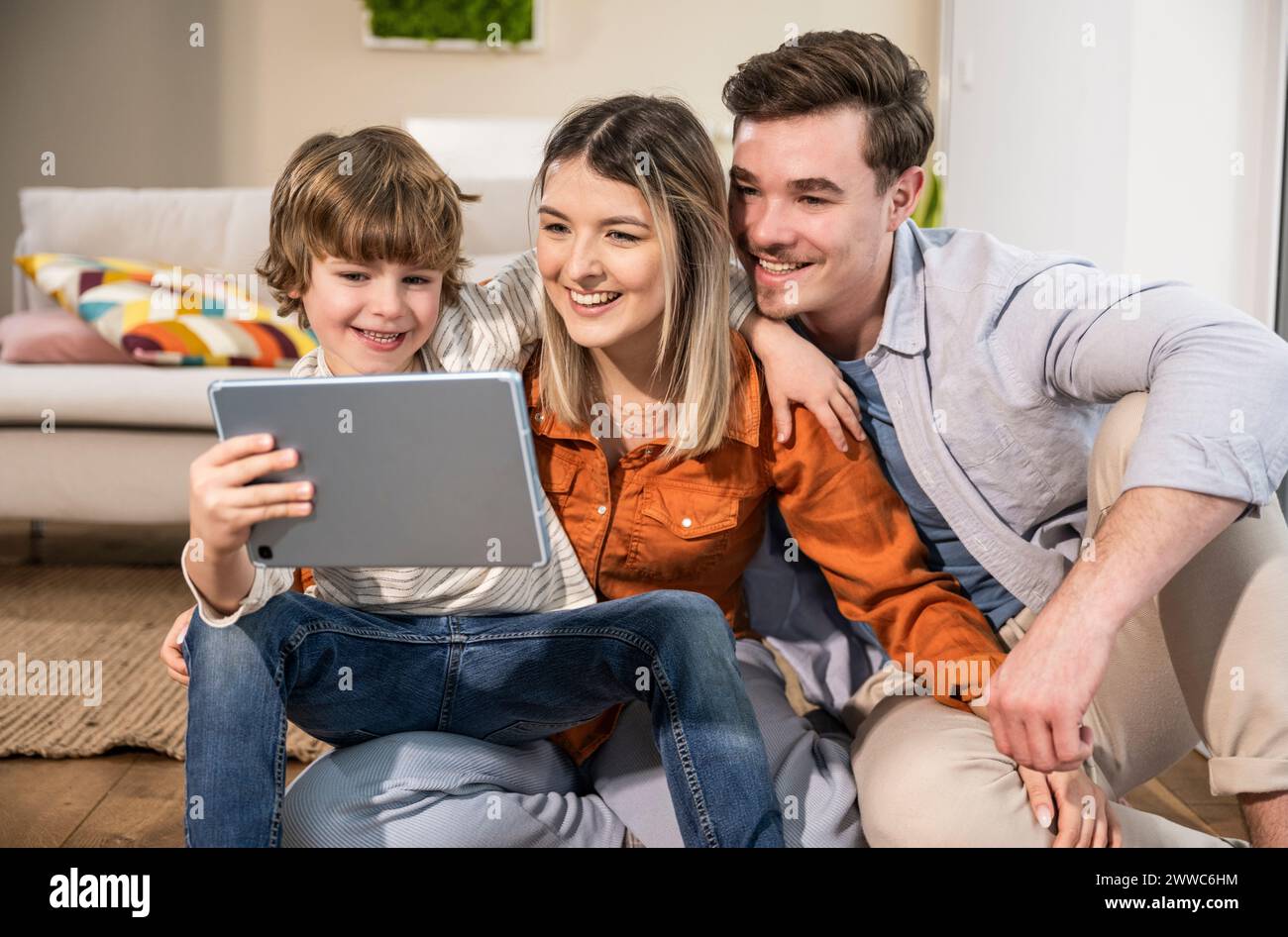 Happy family using tablet PC at home Stock Photo - Alamy
