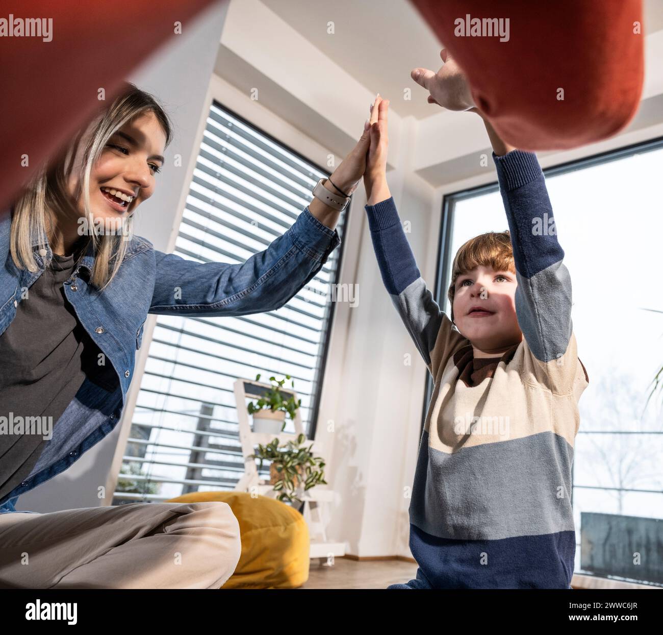 Happy family giving high-five to each other at home Stock Photo - Alamy