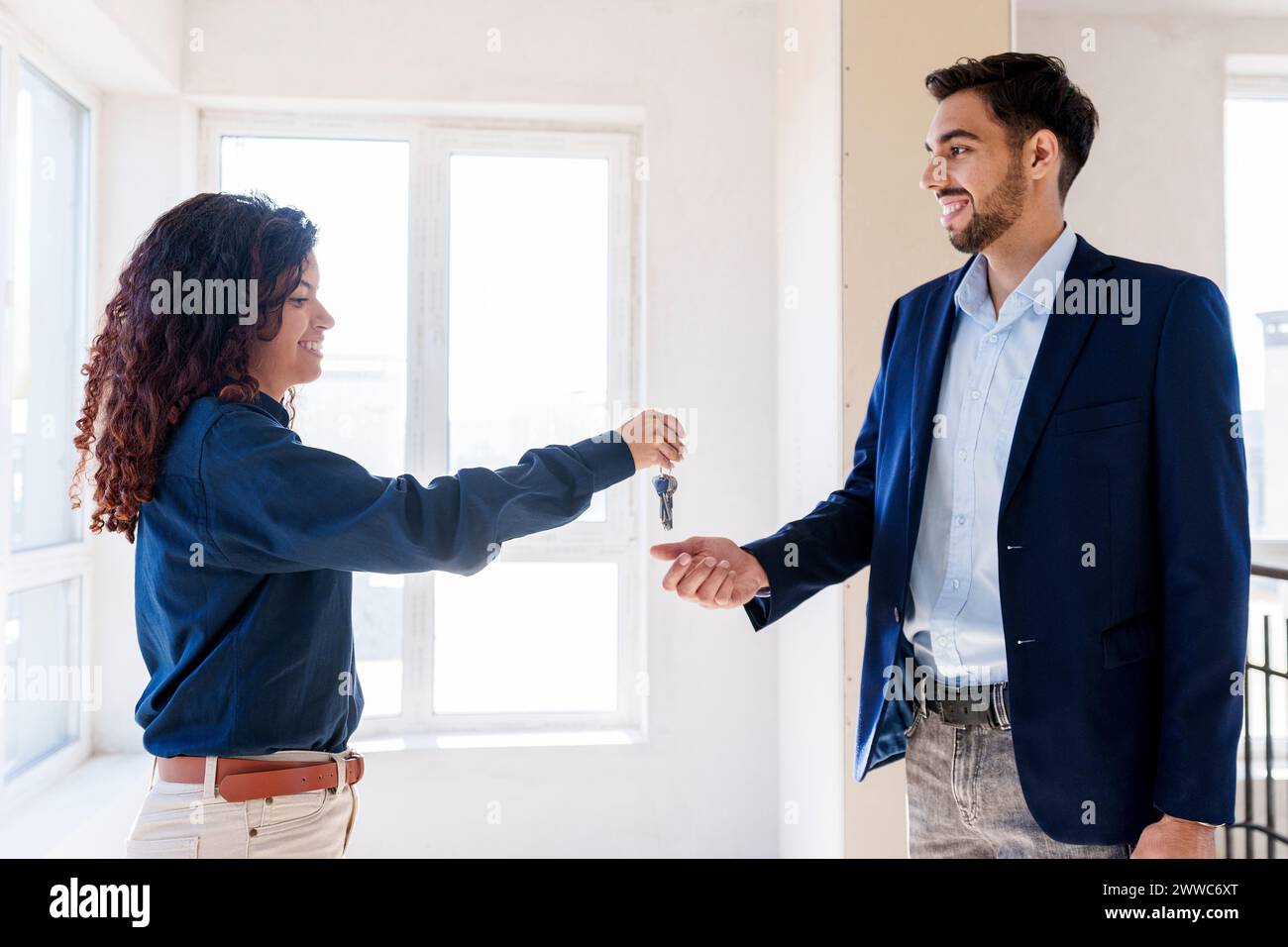 Real estate agent passing house key to new owner at home Stock Photo ...