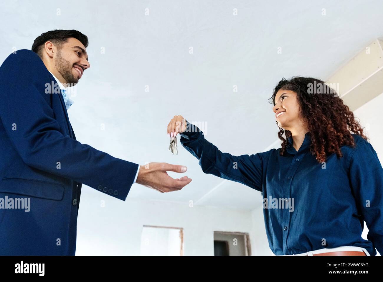 Smiling real estate agent passing keys to new owner of house Stock ...