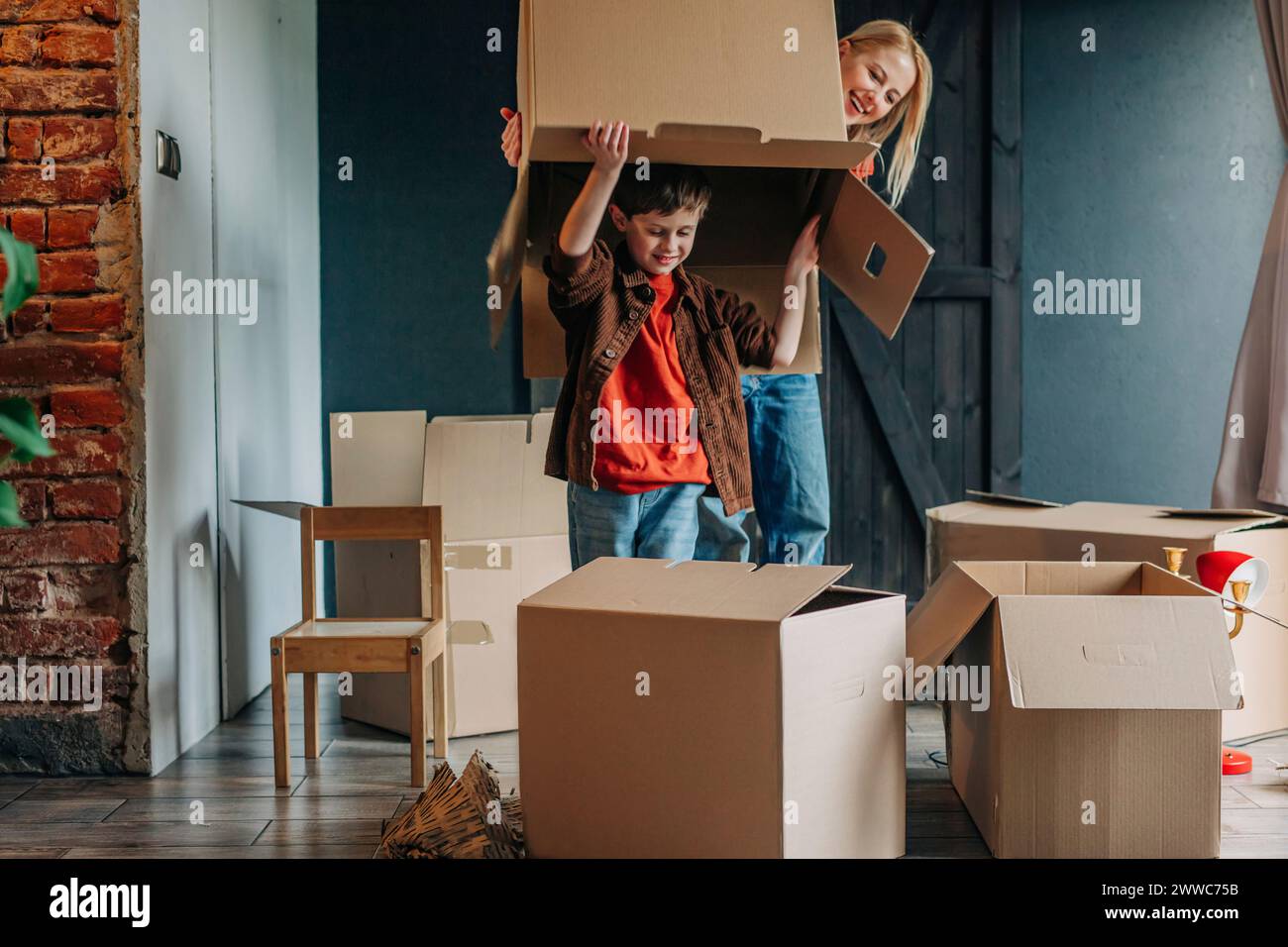 Happy woman with son holding empty cardboard box over head Stock Photo ...