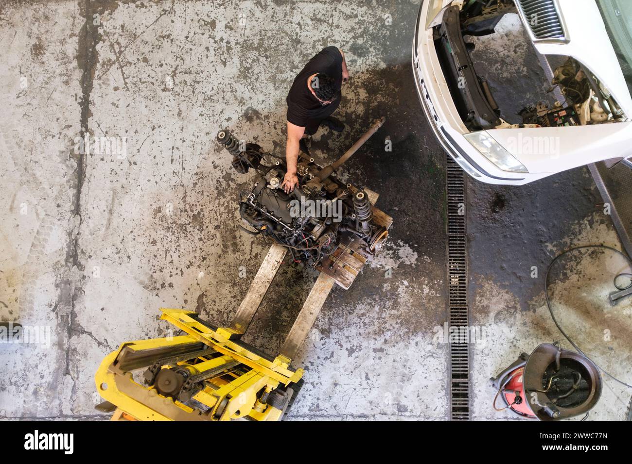 Mechanic disassembling vehicle machine parts at workshop Stock Photo ...