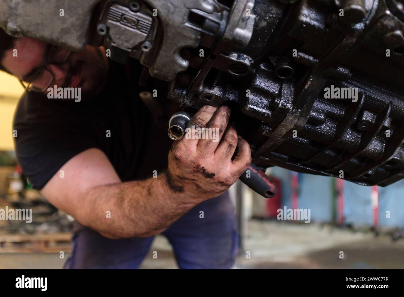 Auto mechanic adjusting parts of engine at workshop Stock Photo - Alamy