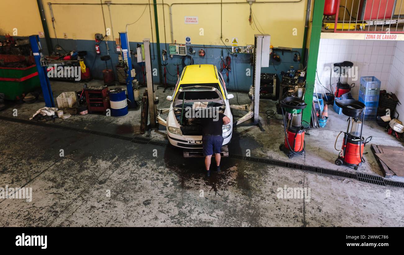Mechanic working on car engine at workshop Stock Photo - Alamy