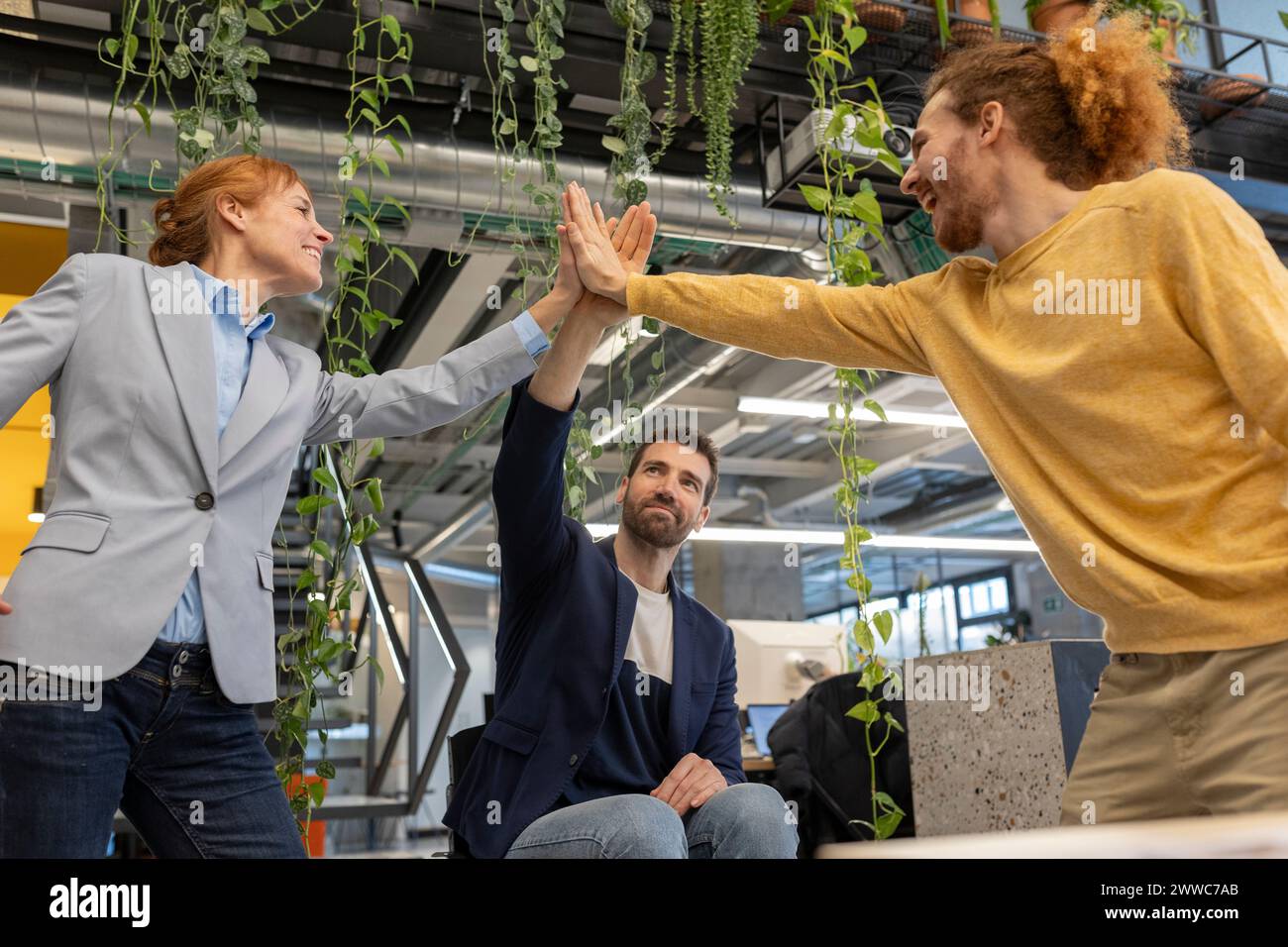 Happy business colleagues giving high-five at office Stock Photo - Alamy