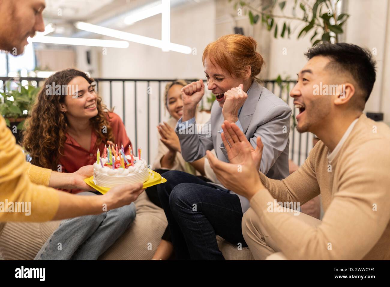 Happy colleagues celebrating birthday with businesswoman at office ...