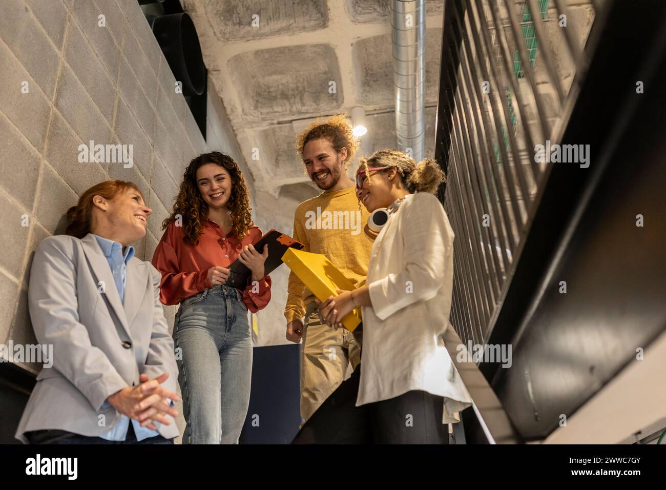 Happy business colleagues discussing on staircase at office Stock Photo ...